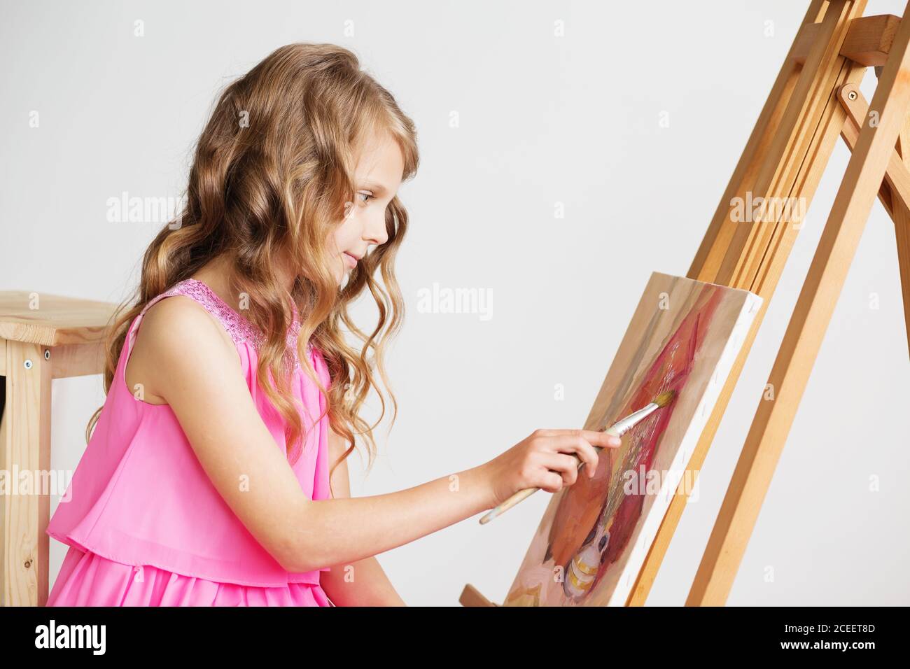Portrait of a lovely little girl painting a picture in a studio or art ...