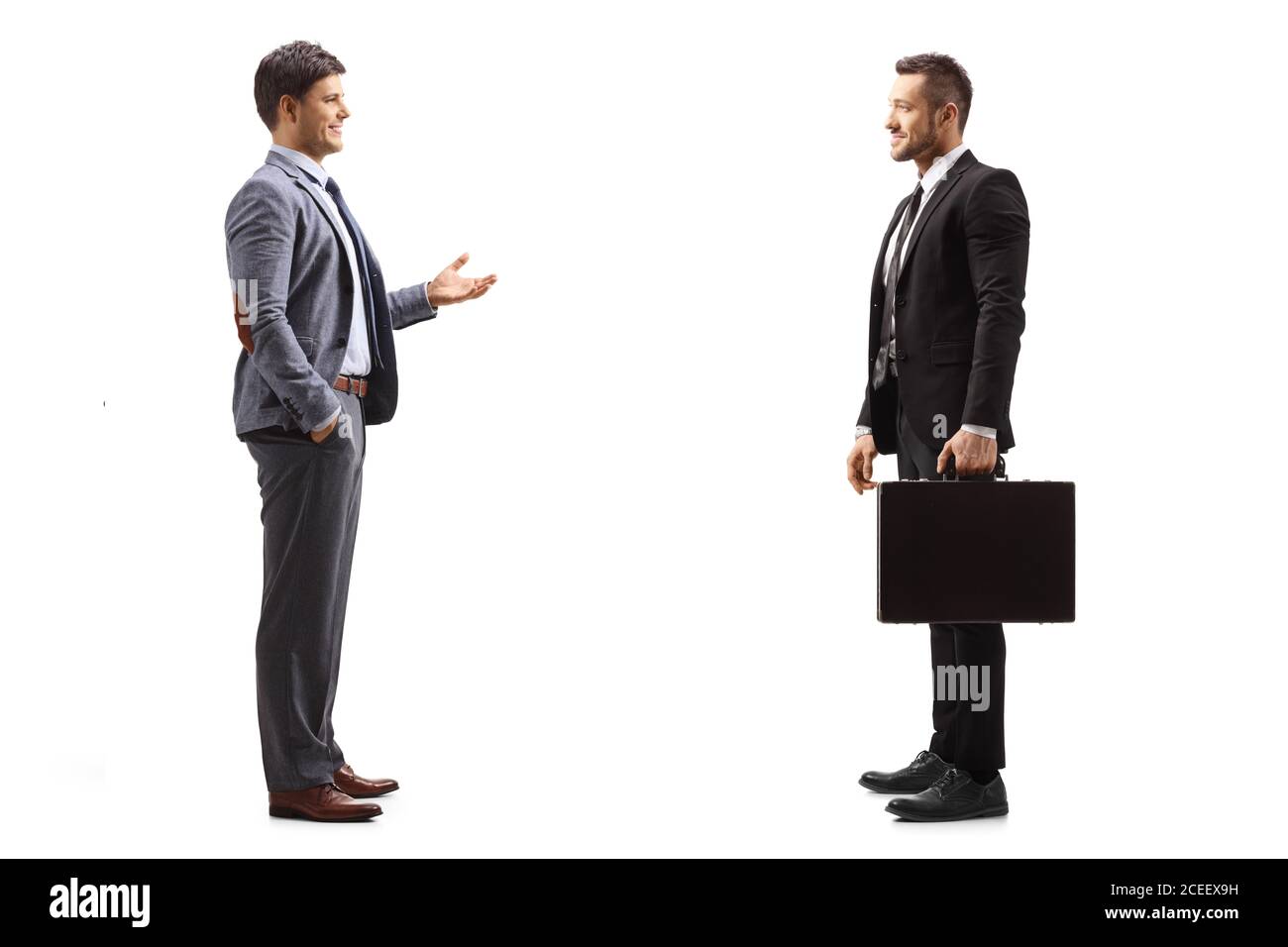Full length profile shot of two businessmen standing and talking ...