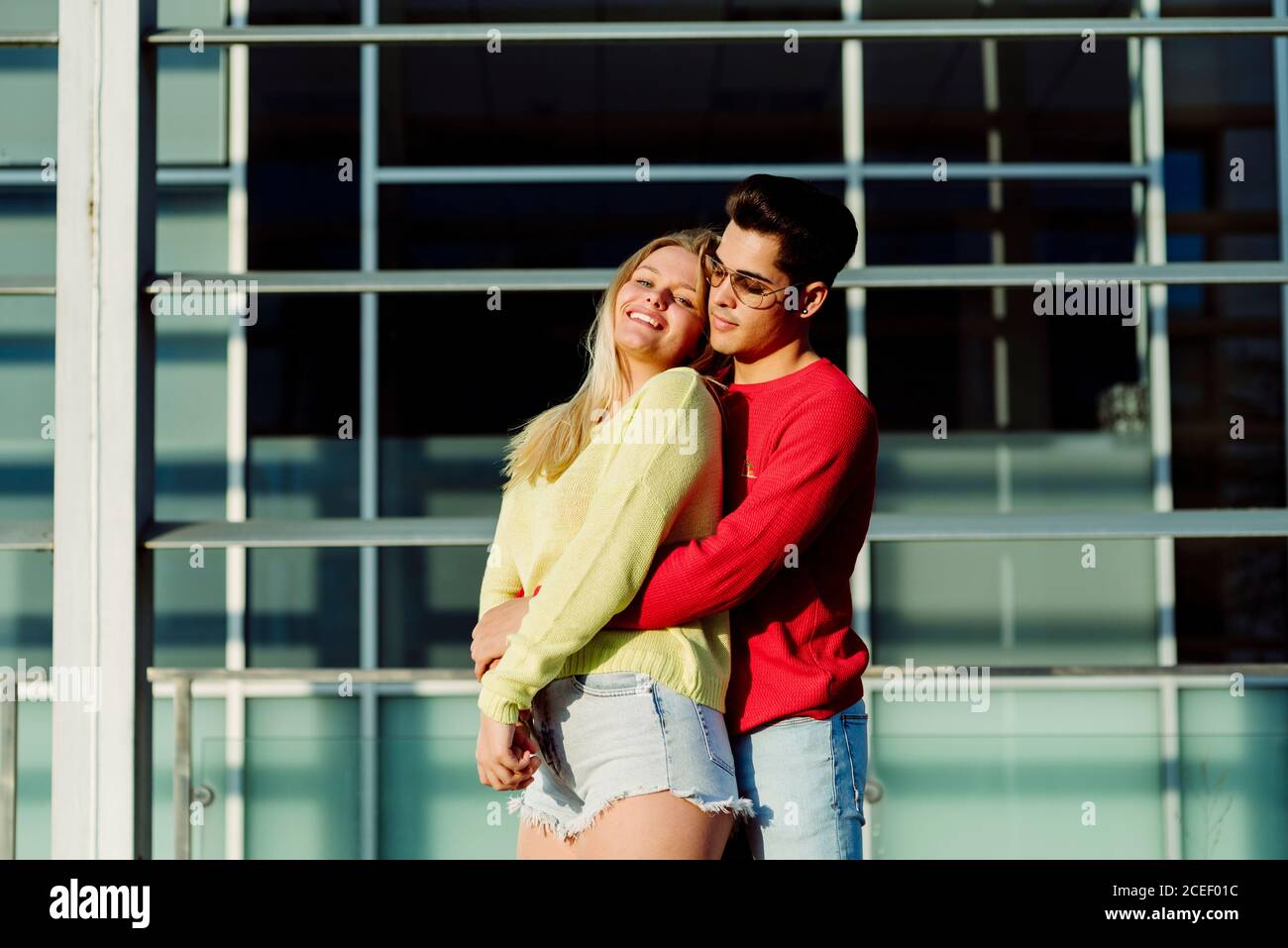 Happy young couple hugging in sunny city hi-res stock photography and ...