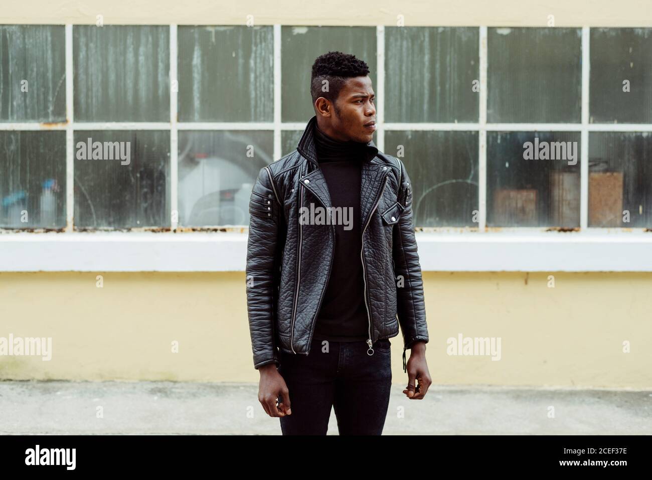 Handsome black man with close eyes standing on windows background Stock ...
