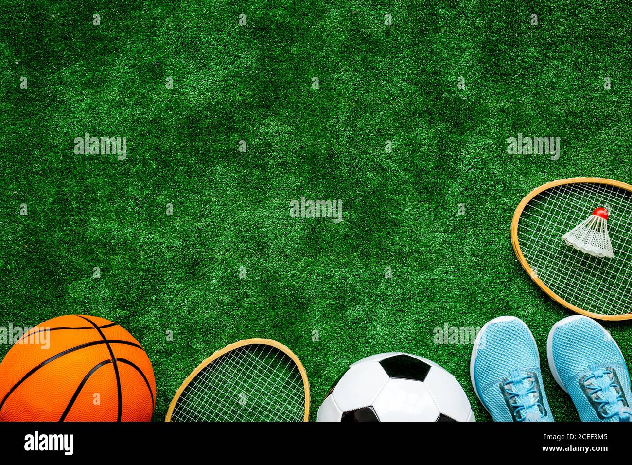 Sport balls and badminton rackets on football grass. Top view copy ...