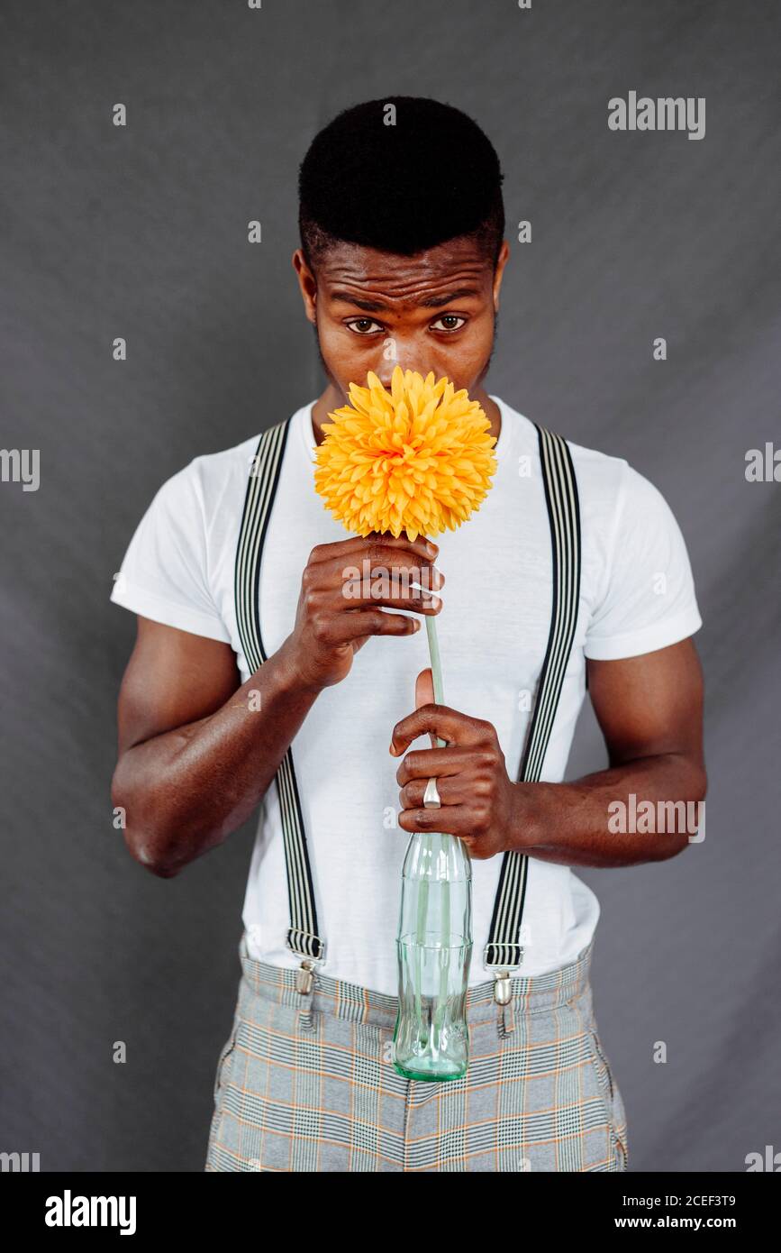 Stylish black man smelling flower Stock Photo - Alamy