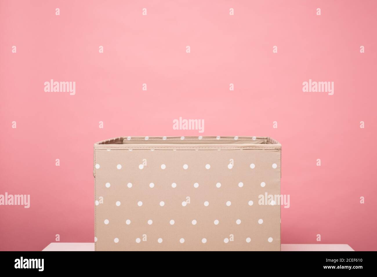 Box with dots on pink studio background Stock Photo - Alamy