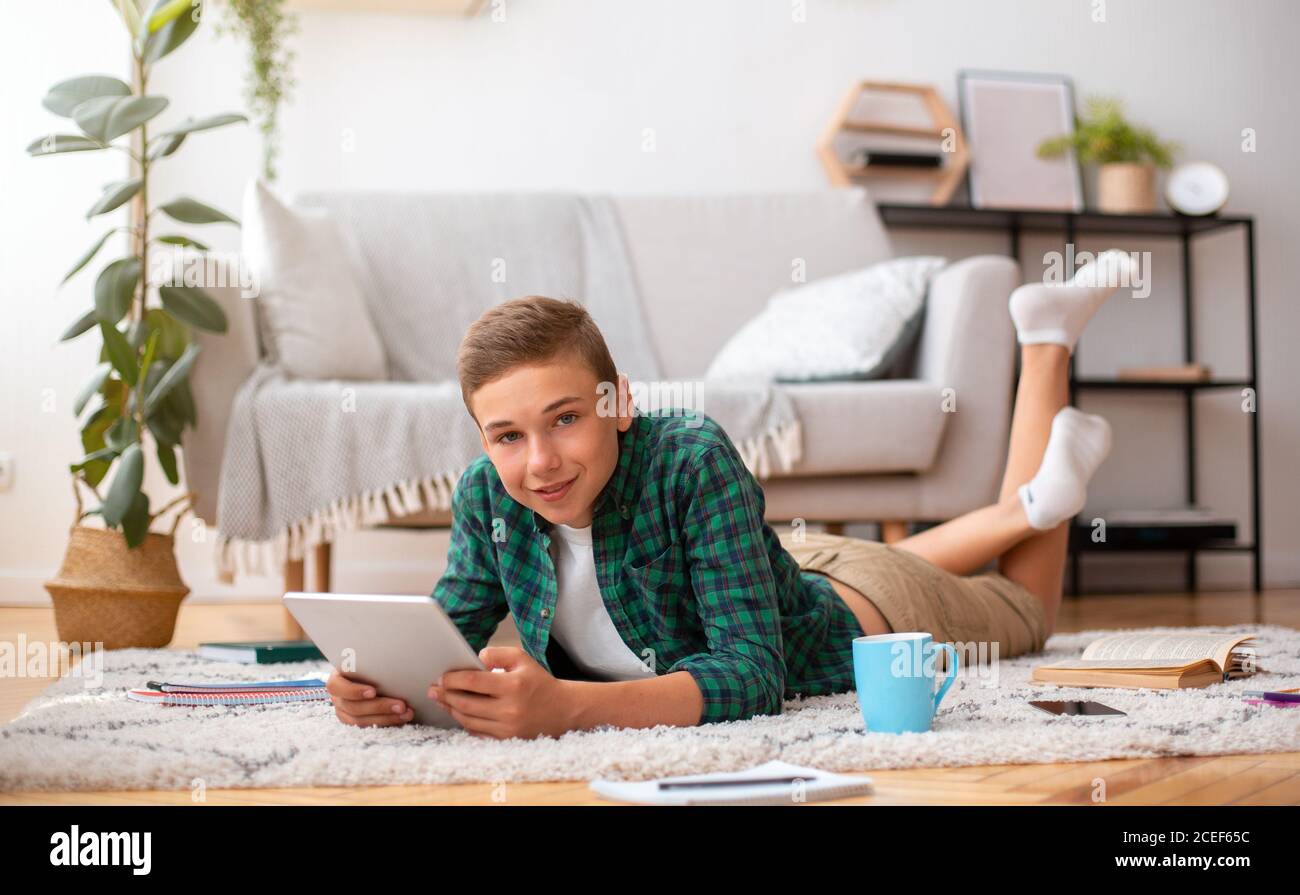 Teen boy using digital tablet while doing homework Stock Photo - Alamy