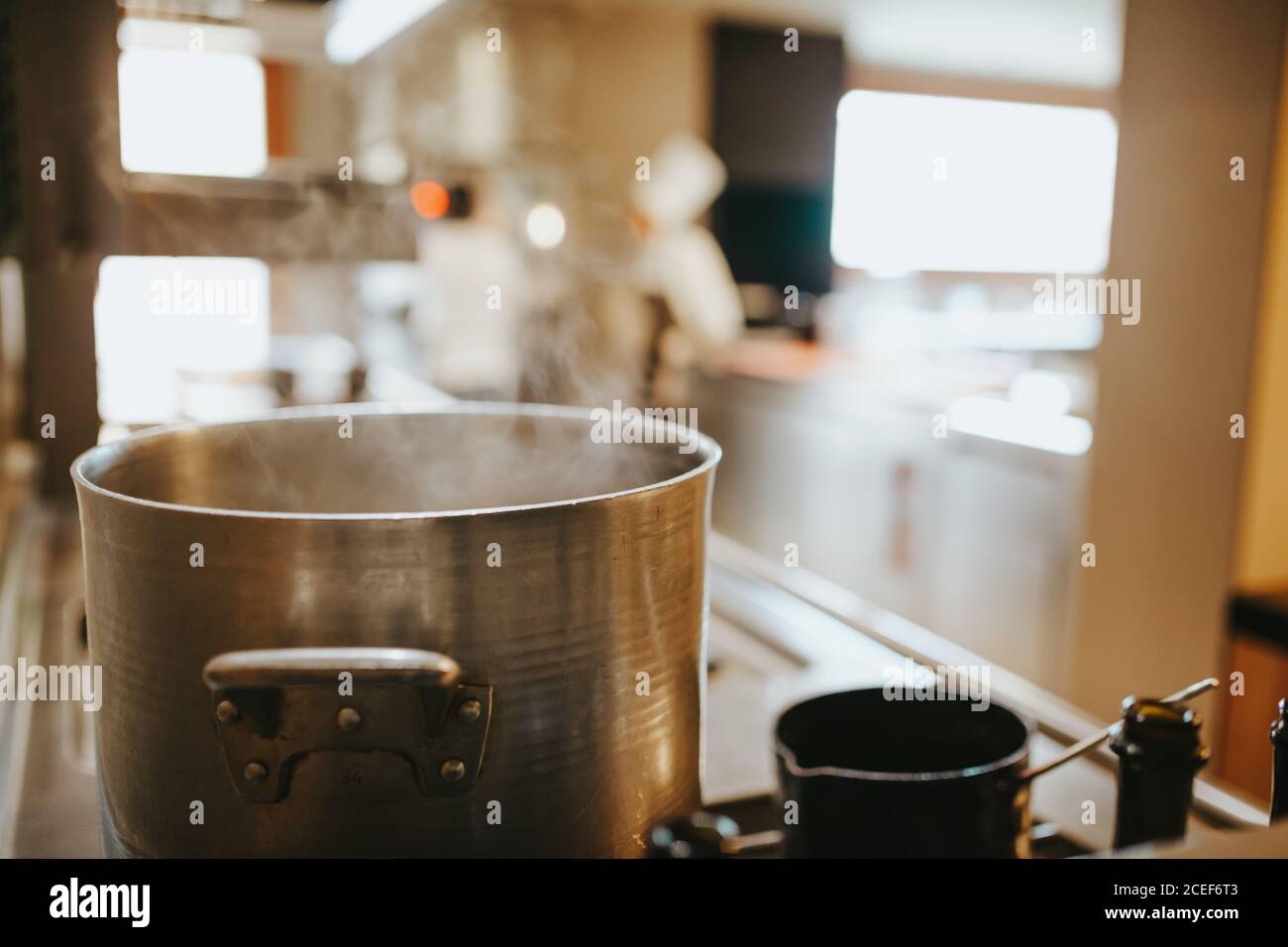 The pot in the kitchen with the steam over it. Horizontal indoors shot ...