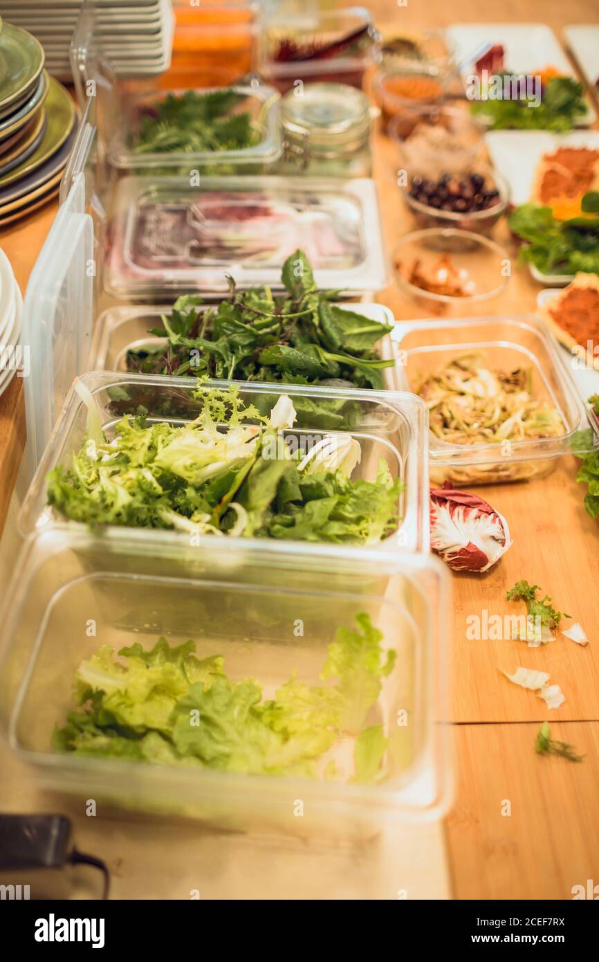 Containers with different green lettuce on kitchen of restaurant Stock ...