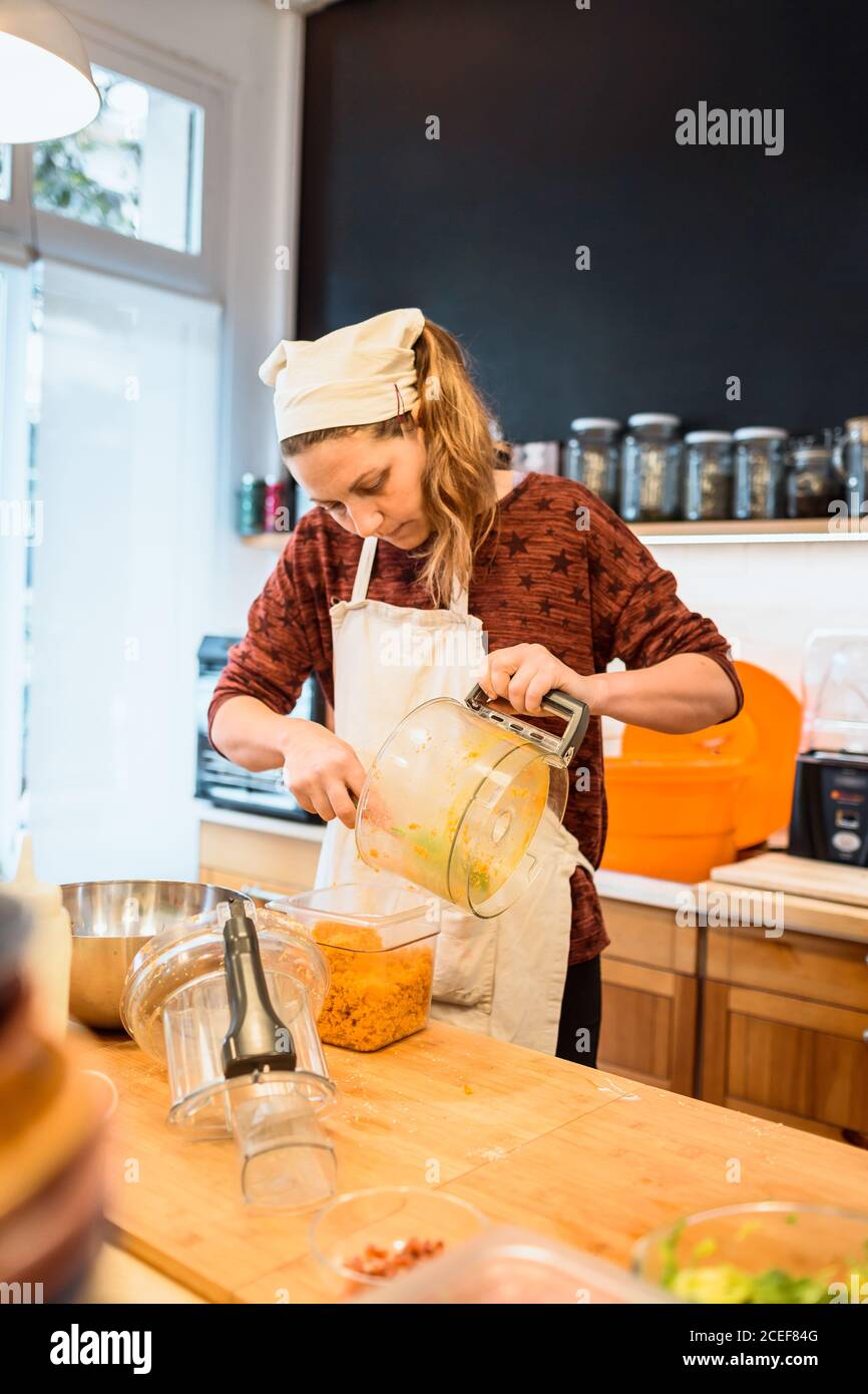 Cook putting ingredients to blender Stock Photo - Alamy