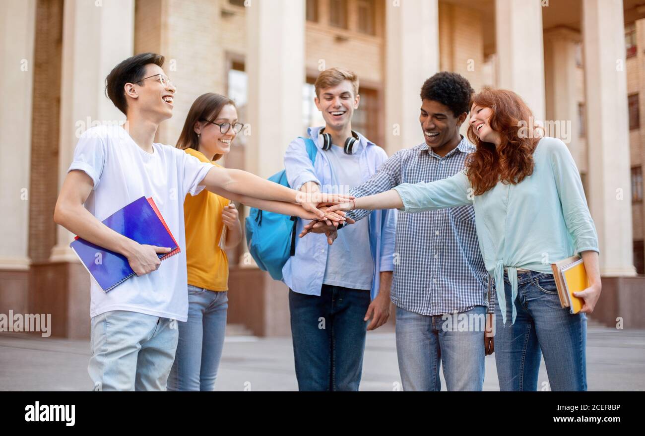 Students Holding Hands Standing In Circle Outside University Building ...