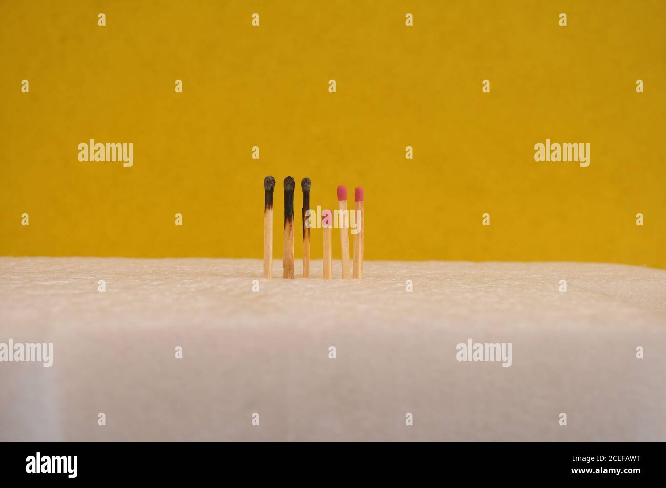 Match sticks, side by side on white base and blue background ...