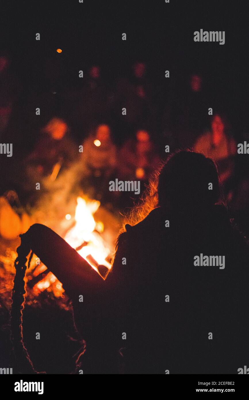 Group of people gathering around fire in woods Stock Photo - Alamy