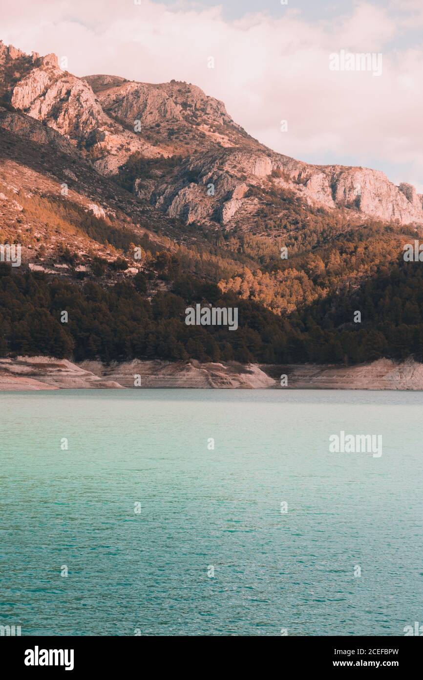 Lake near mountain slope Stock Photo - Alamy