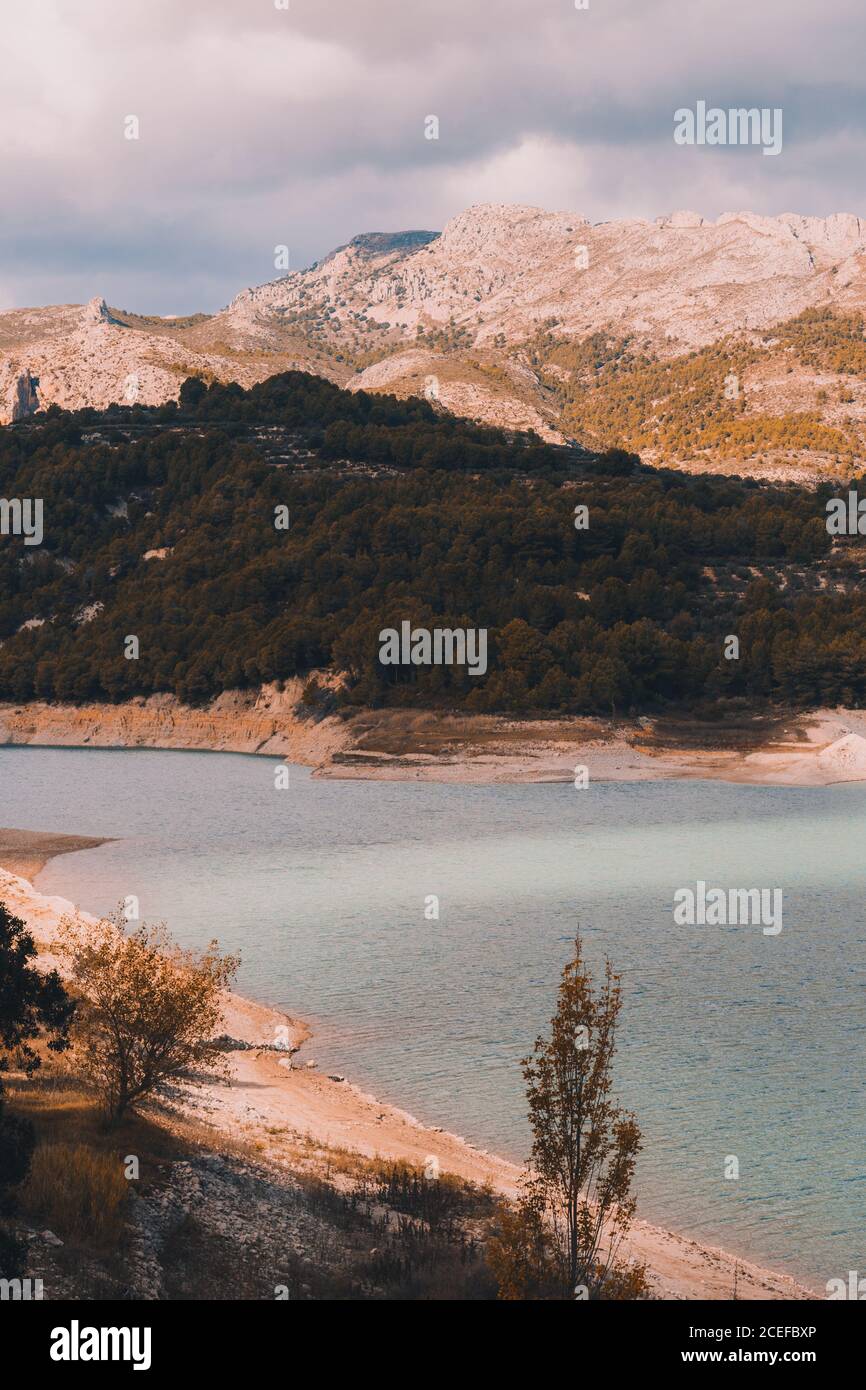 Lake near mountain slope Stock Photo - Alamy