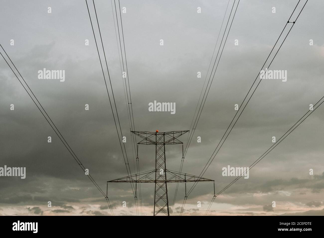 Minimalist view of black wires and high voltage power pole on ...
