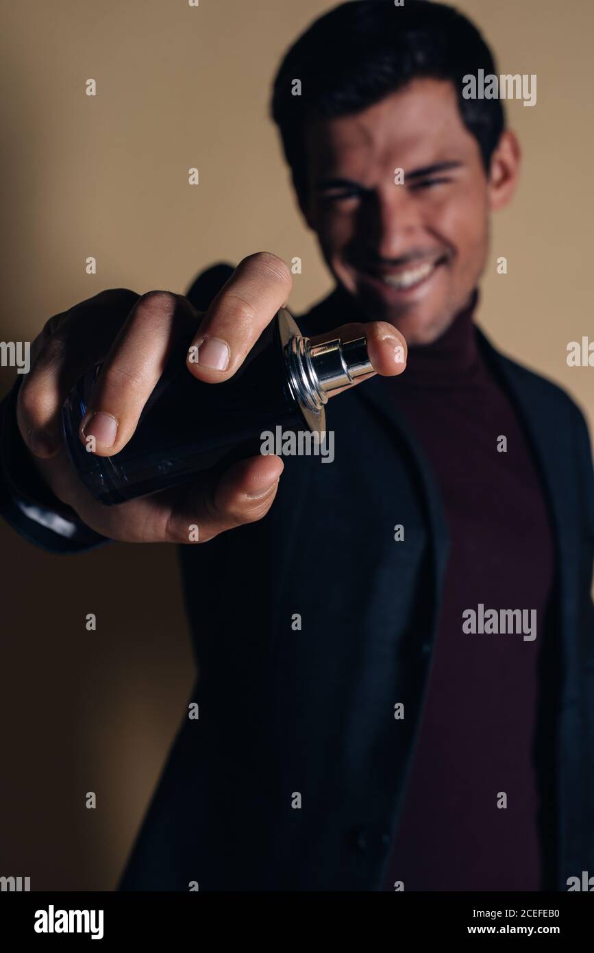 Young business man in a studio applying perfume Stock Photo - Alamy