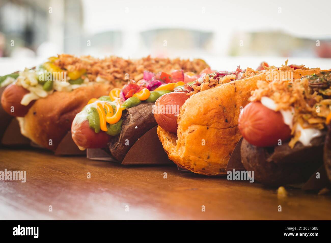 Row of assorted hot dogs with different delicious toppings and fillings ...