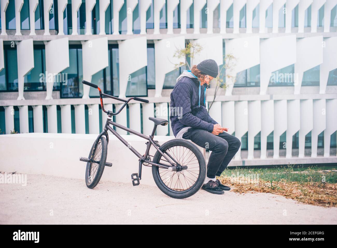 Young man poses with mobile and BMX bike Stock Photo - Alamy