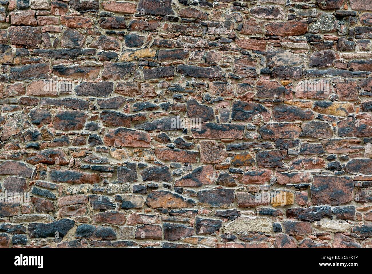 A "horizontal view of colorful sandstone massive stone wall background ...