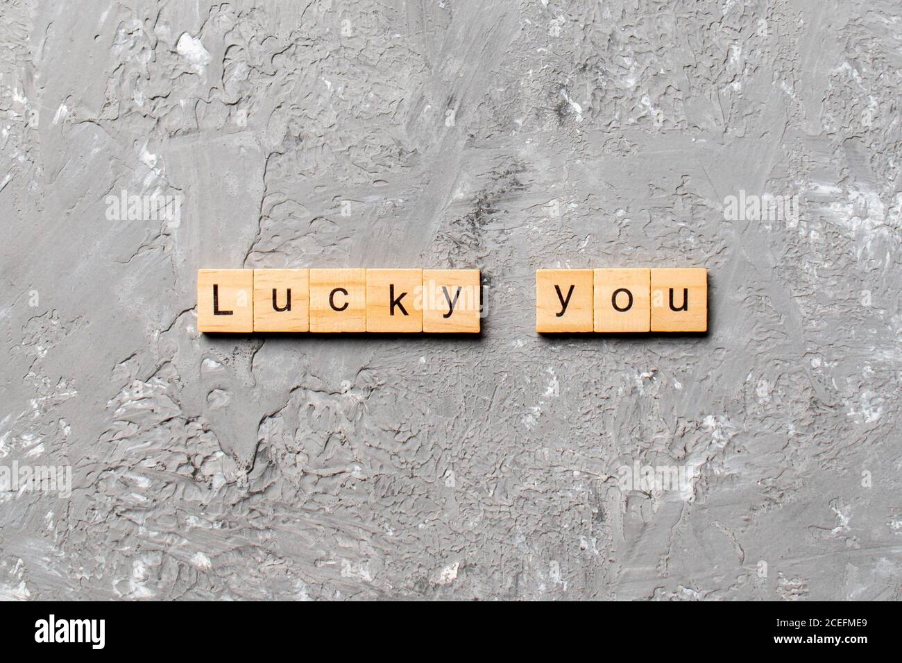 Lucky you word written on wood block. Lucky you text on cement table ...
