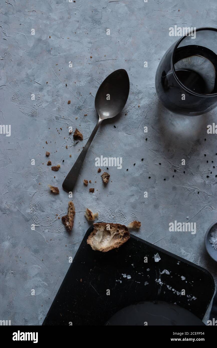 crumbs of fresh bread and metal spoon lying on plaster surface Stock ...