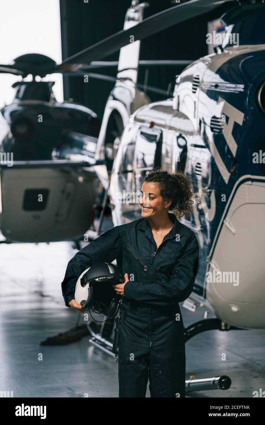 Pilot girl poses with her helicopter and helmet Stock Photo - Alamy