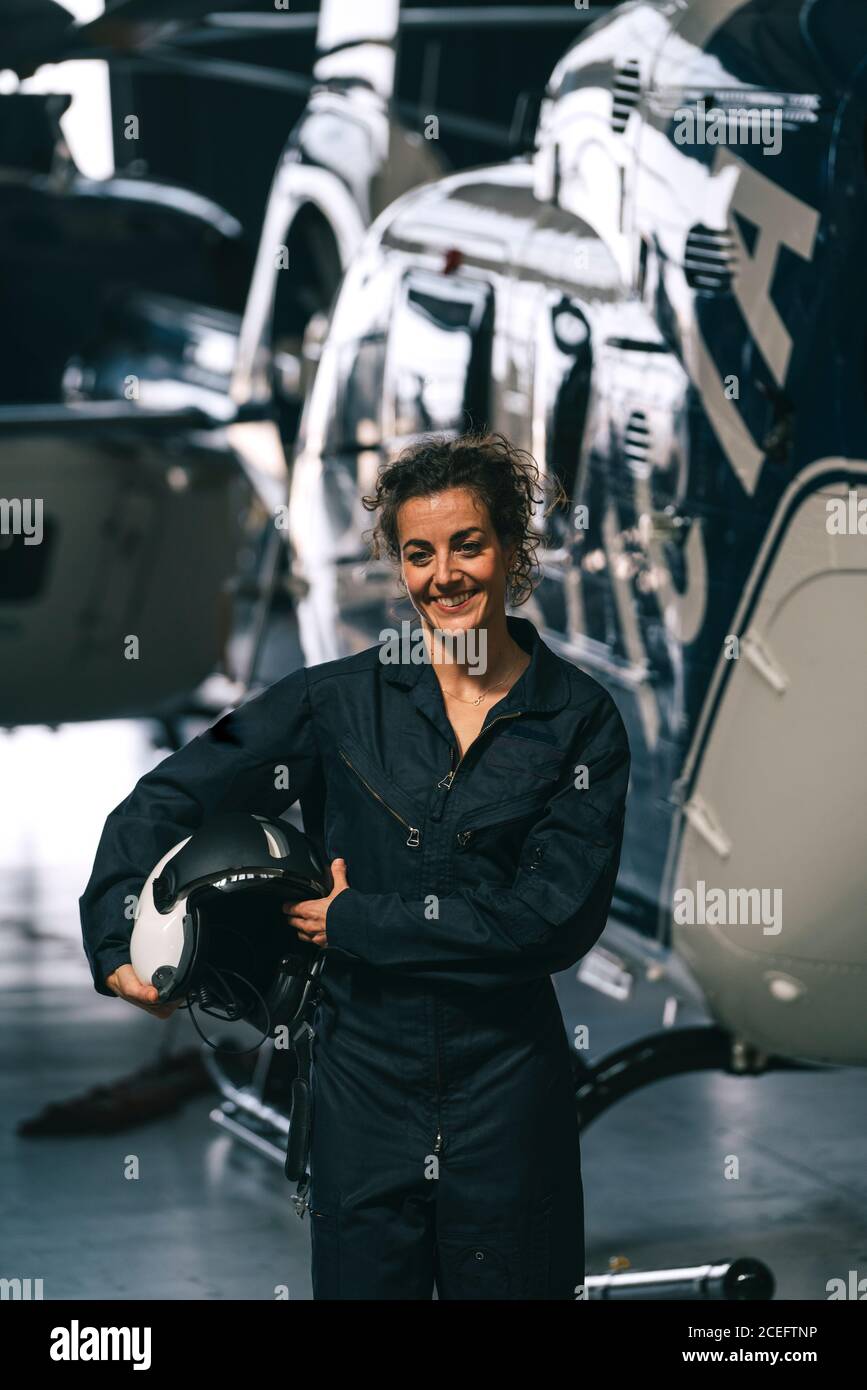 Pilot girl poses with her helicopter and helmet Stock Photo - Alamy