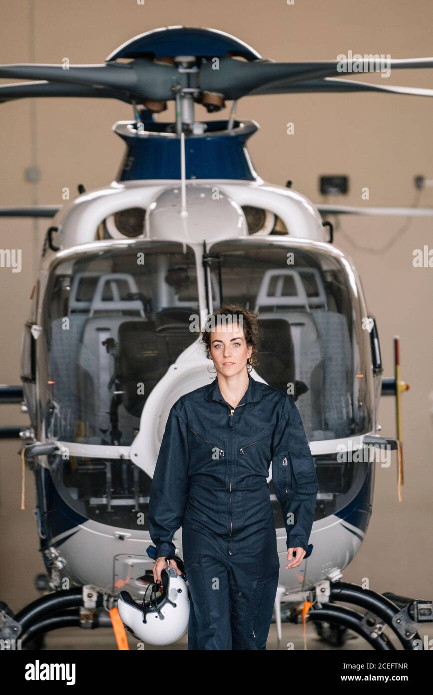 Pilot girl poses with her helicopter and helmet Stock Photo - Alamy
