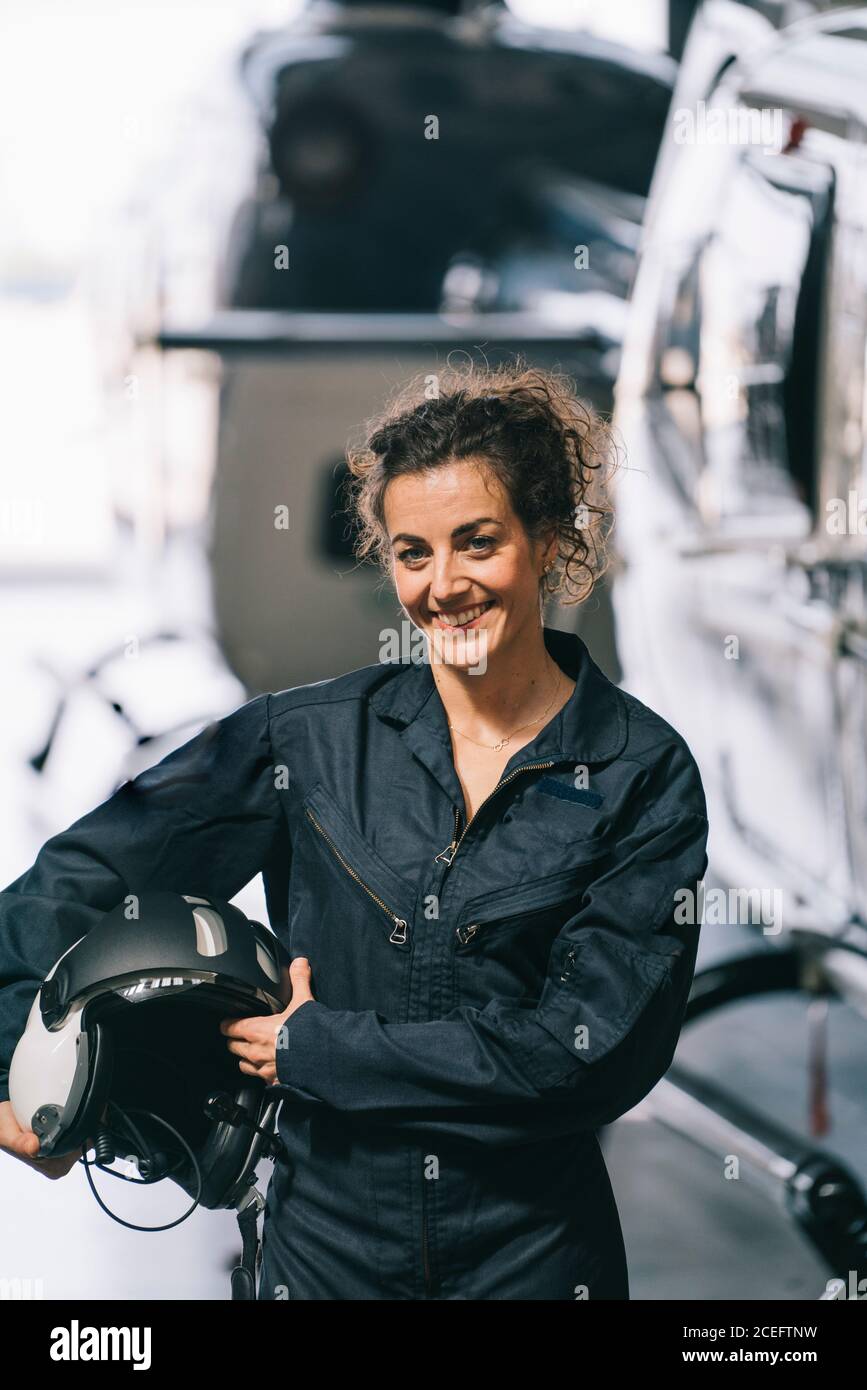 Pilot girl poses with her helicopter and helmet Stock Photo - Alamy