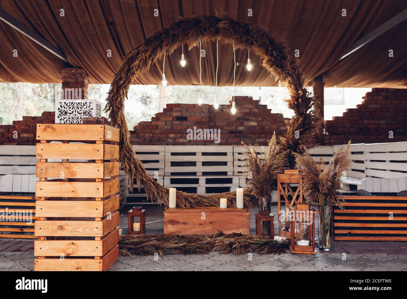 Wedding boho ceremony round arch decorated with reeds, lights, candles ...