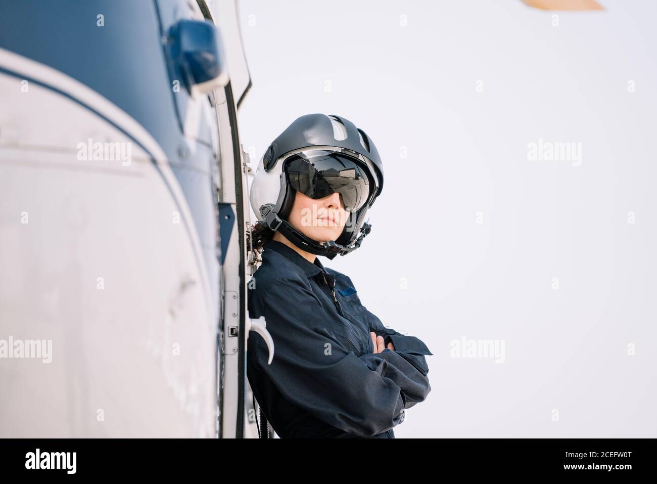 Pilot girl poses with her helicopter and helmet Stock Photo - Alamy
