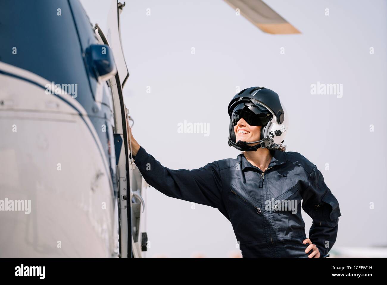 Pilot girl poses with her helicopter and helmet Stock Photo - Alamy