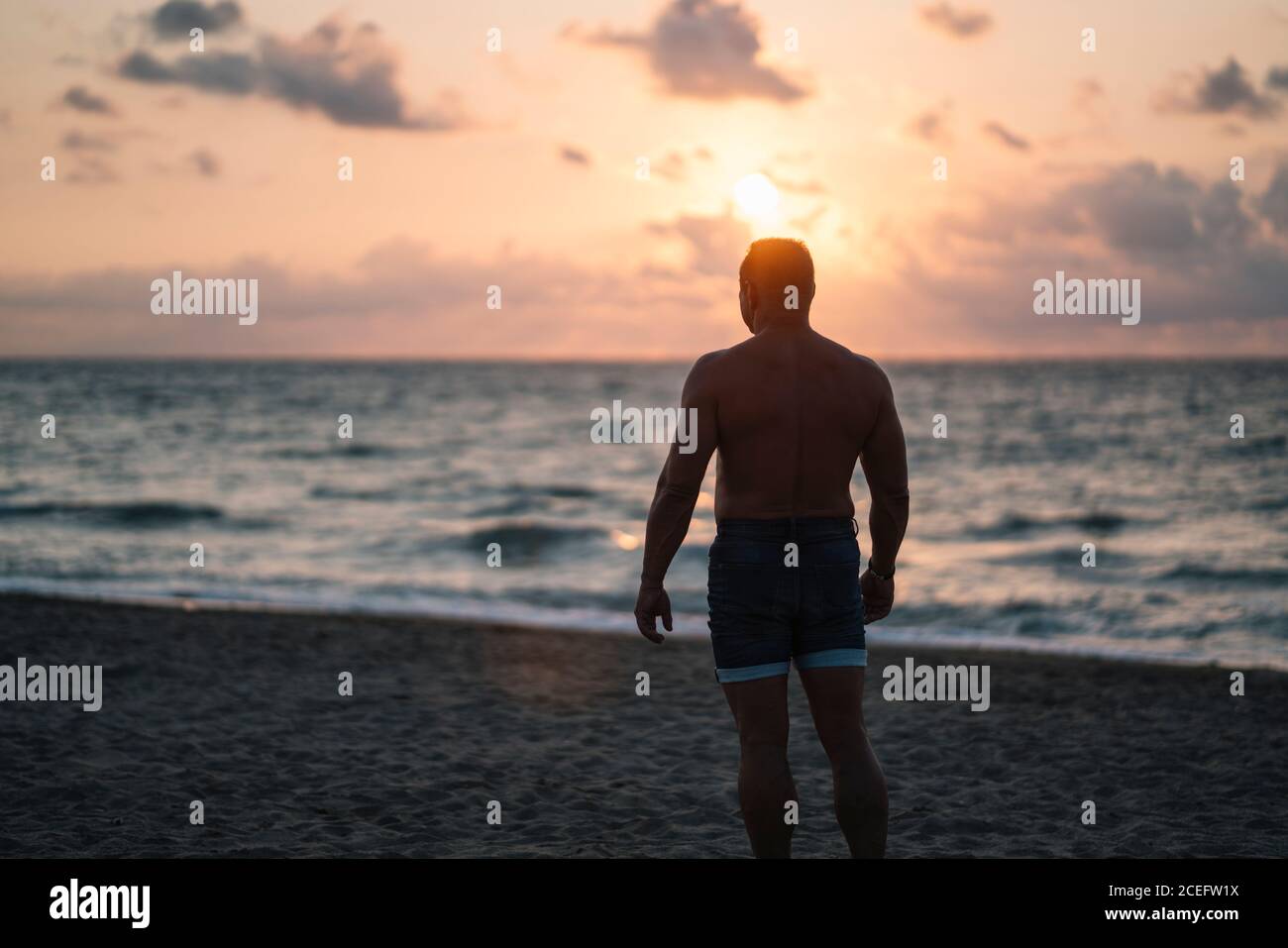 Strong old man posing on beach Stock Photo - Alamy