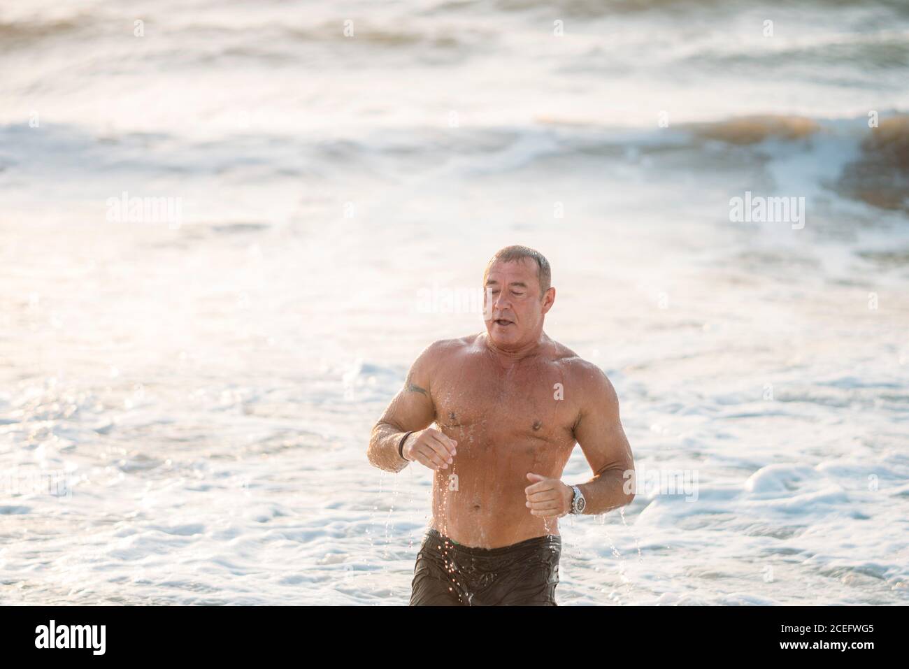Strong old man makes exercise on the beach Stock Photo - Alamy