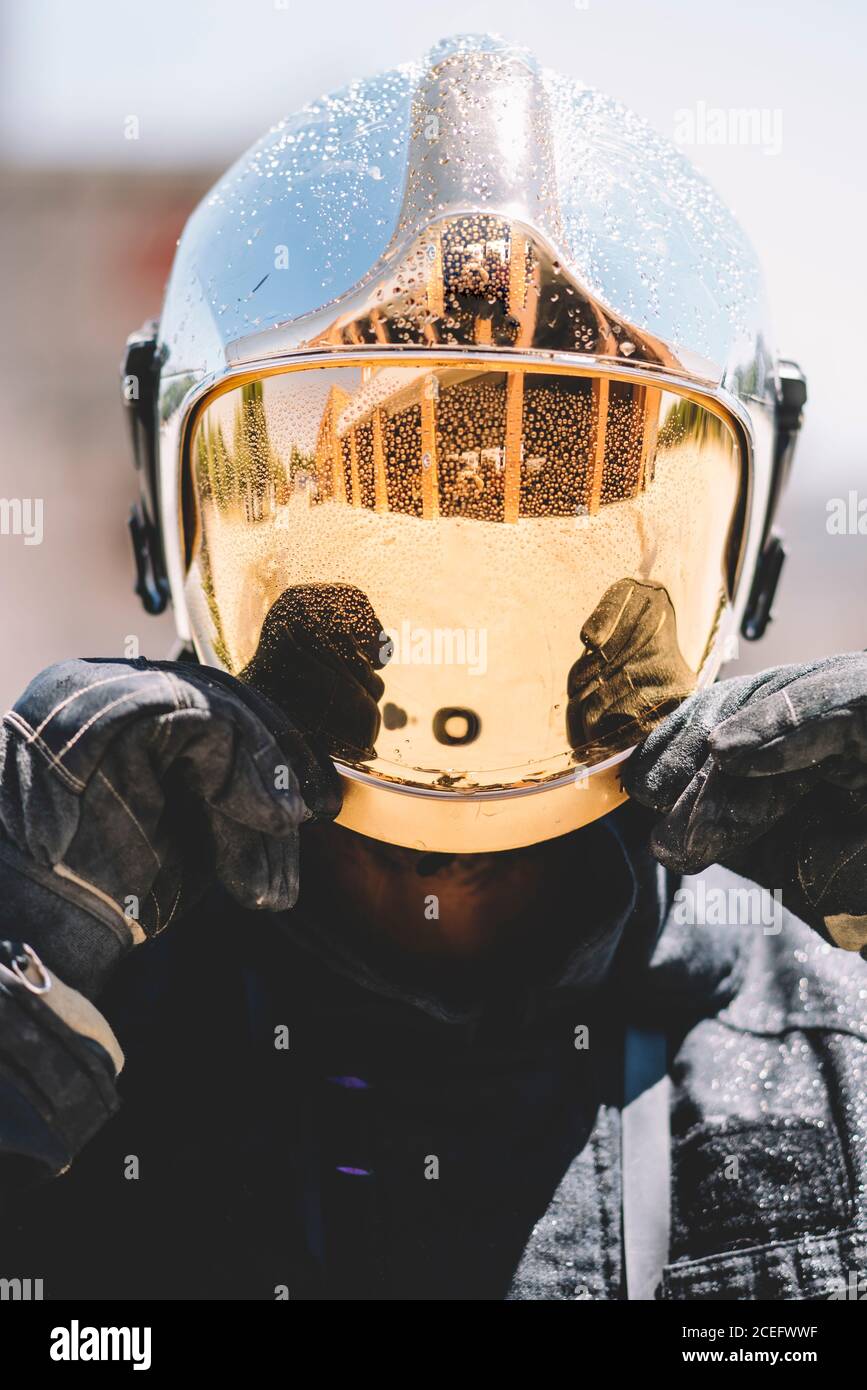 Firefighter poses with helmet looking at camera Stock Photo - Alamy