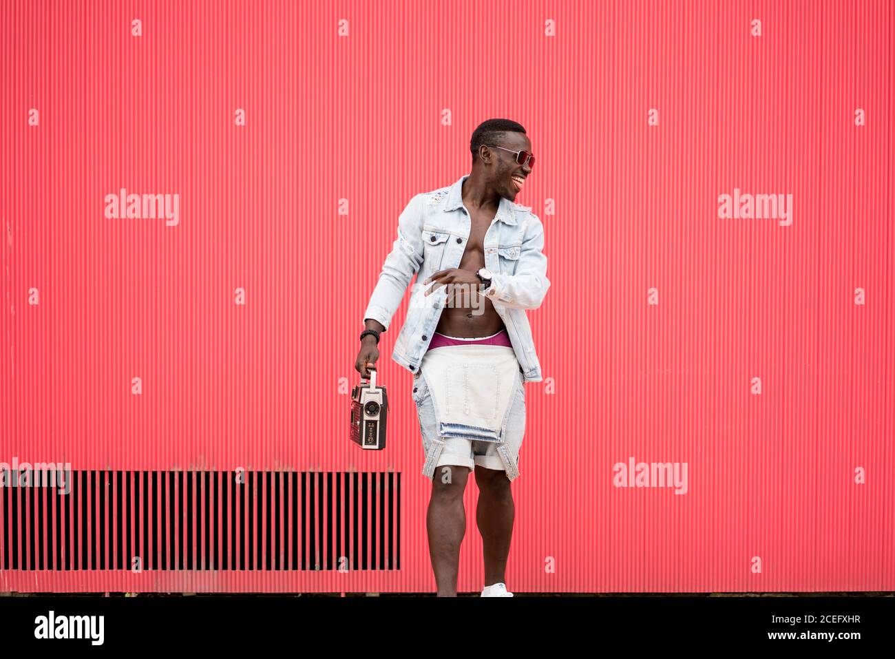 African man red background with vintage radio device Stock Photo - Alamy
