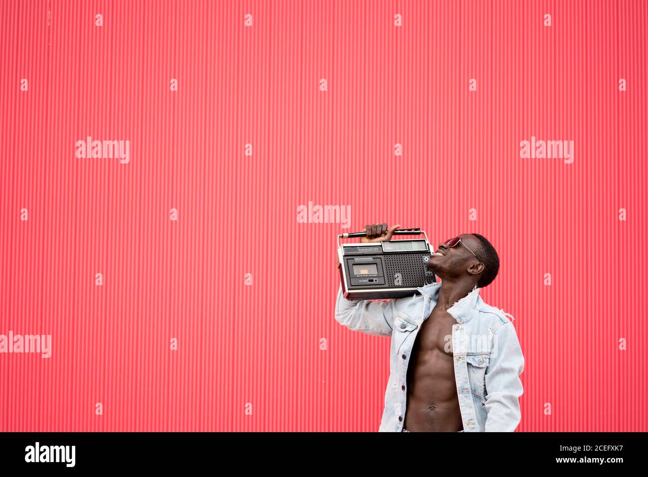 African man red background with vintage radio device Stock Photo - Alamy