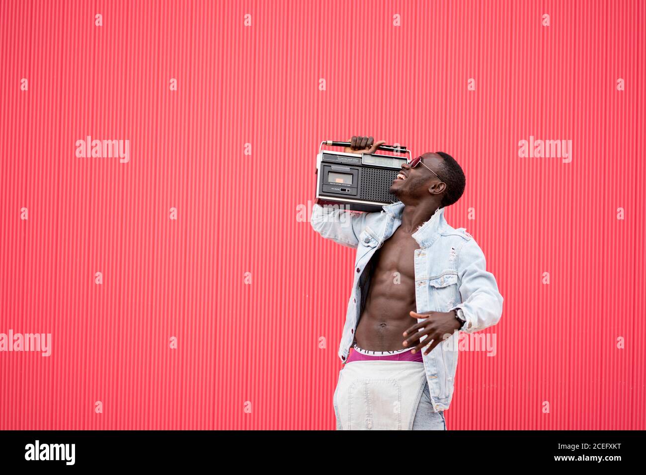African man red background with vintage radio device Stock Photo - Alamy