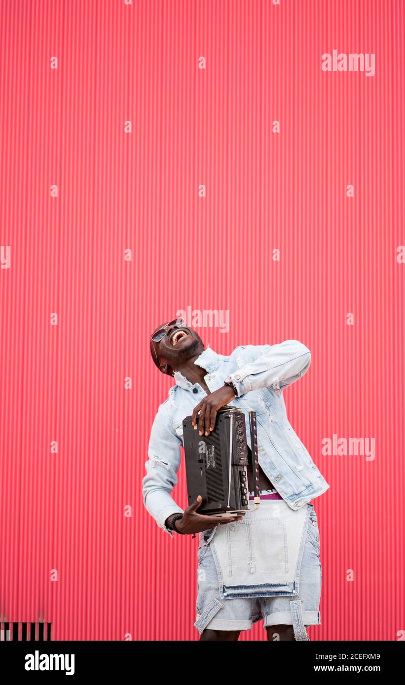 African man red background with vintage radio device Stock Photo - Alamy