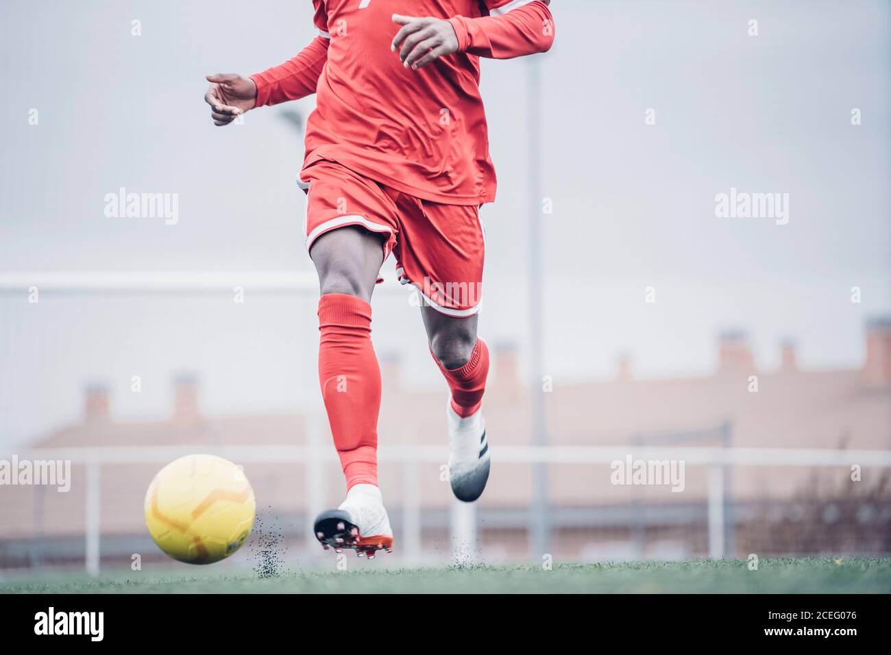 African soccer player with red outfit playing soccer Stock Photo - Alamy