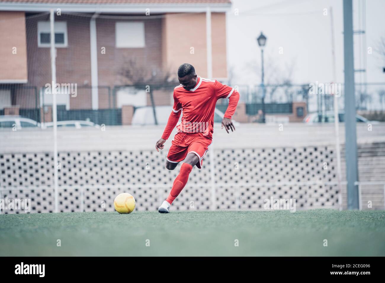 African soccer player with red outfit playing soccer Stock Photo - Alamy