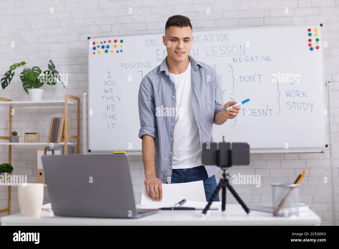 Online classroom remotely. Friendly teacher looks at camera and answers ...
