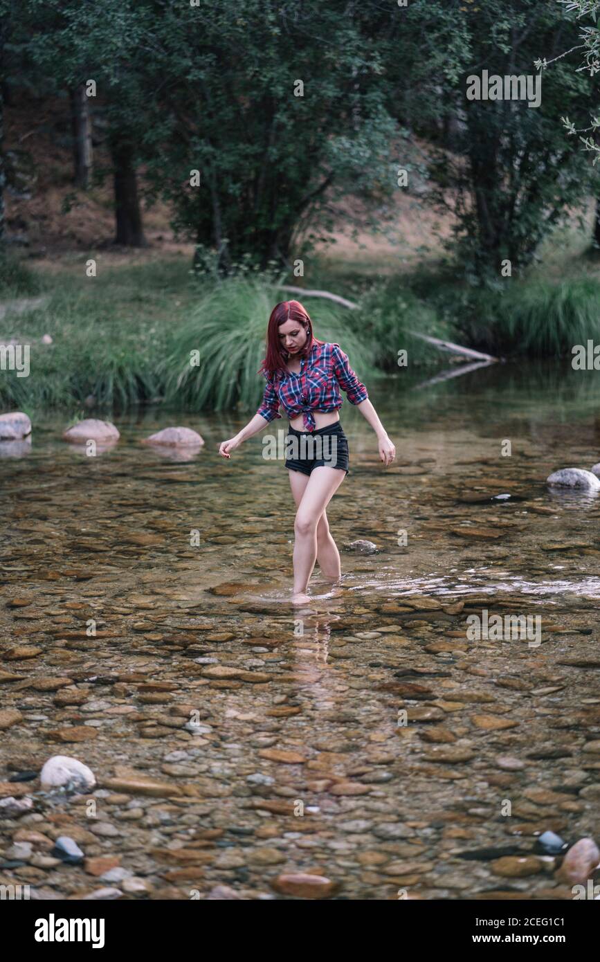 Pretty red haired girl walking along the river Stock Photo - Alamy