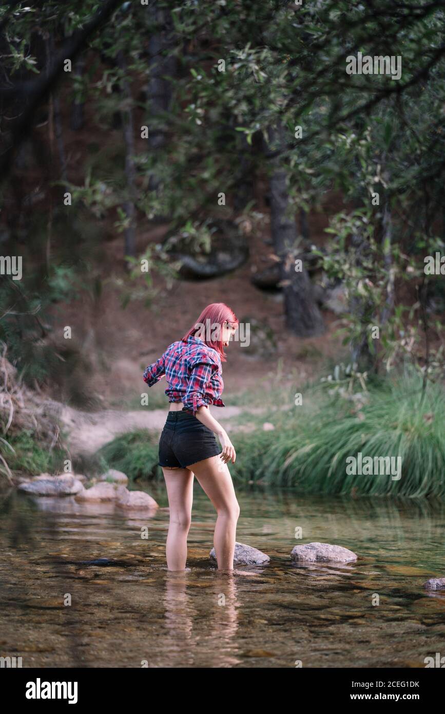 Pretty red haired girl walking along the river Stock Photo - Alamy