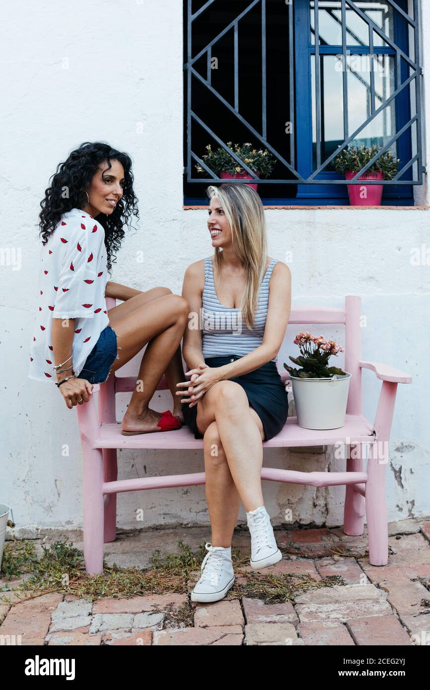 Two girls sitting on a bench hi-res stock photography and images - Alamy