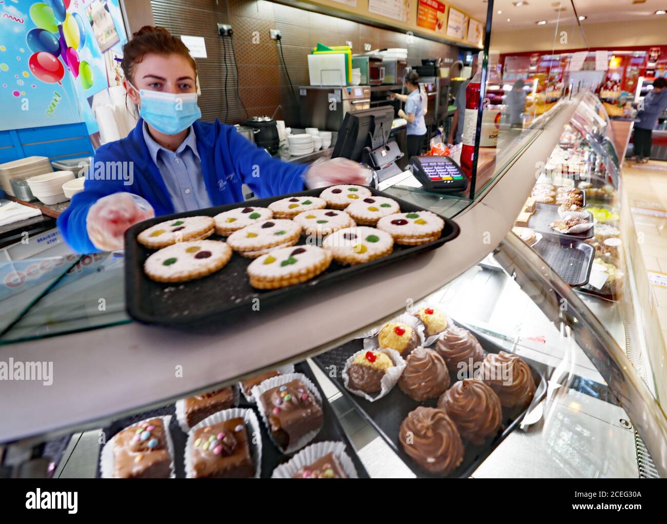 Shop assistant Kim O'Brien stocks a display of cakes at Bradbury's ...