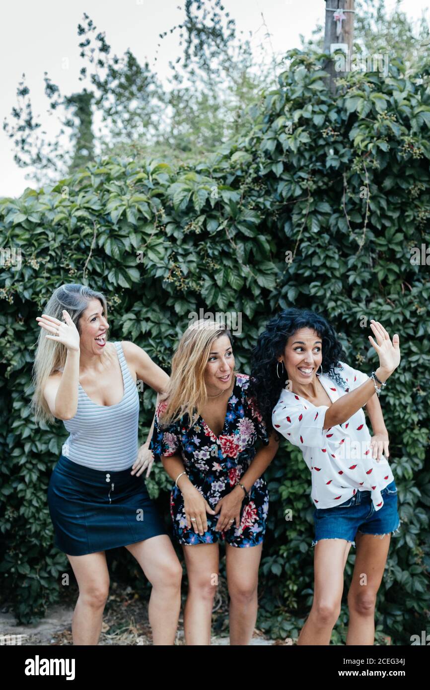 Three girls greeting on the street Stock Photo - Alamy