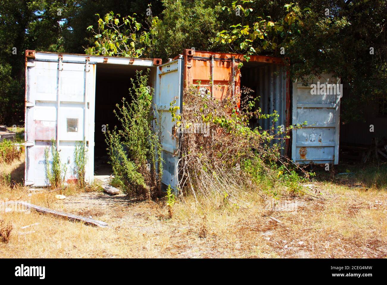 large empty containers made of rusted steel abandoned among dirt in a ...