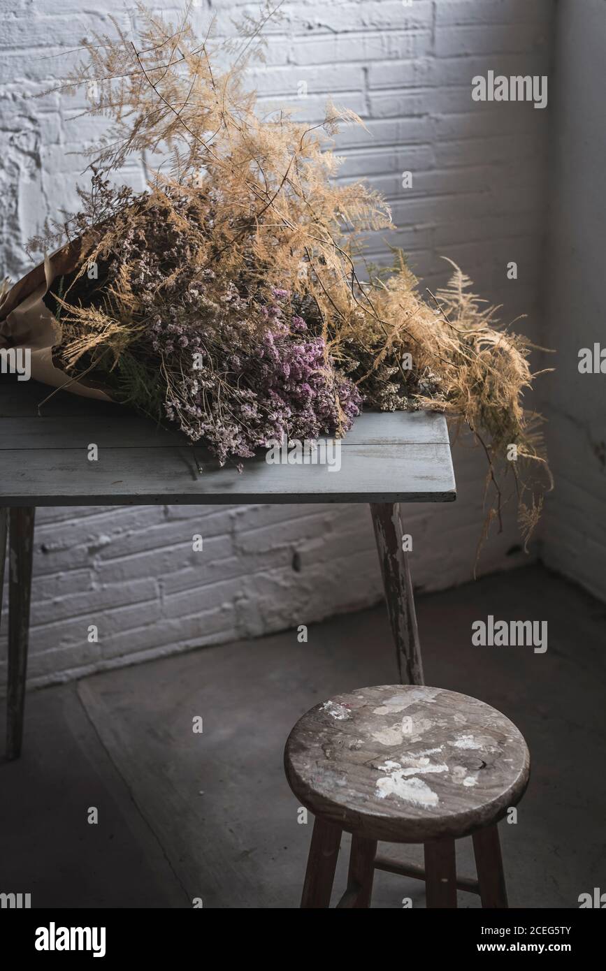 Concept of bouquet of dry coniferous twigs in craft paper on table near ...