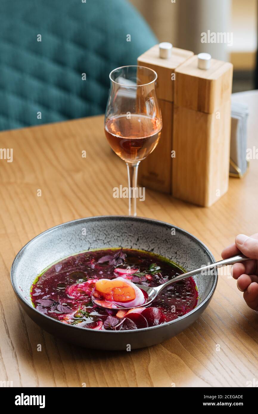 Crop view of hand holding shiny metal spoon full of delicious Nordic ...