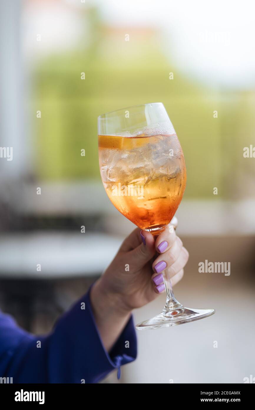 Crop female hand holding steamy glass filled with ice and sophisticated ...