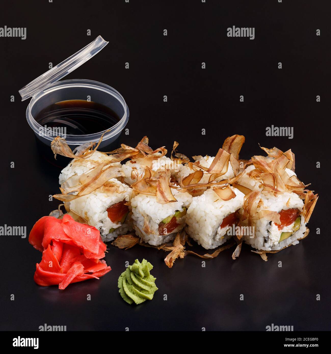 Traditional delicious fresh Bonito with trout sushi roll set on a black ...